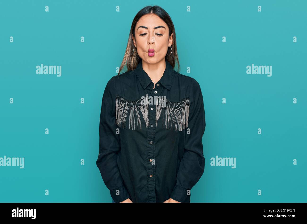 Young hispanic woman wearing casual clothes making fish face with lips ...