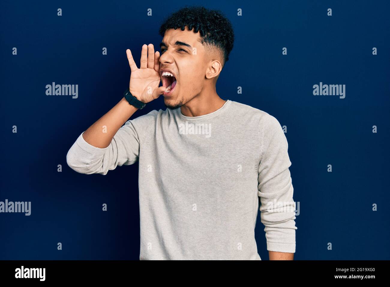 Young african american man wearing casual clothes shouting and ...