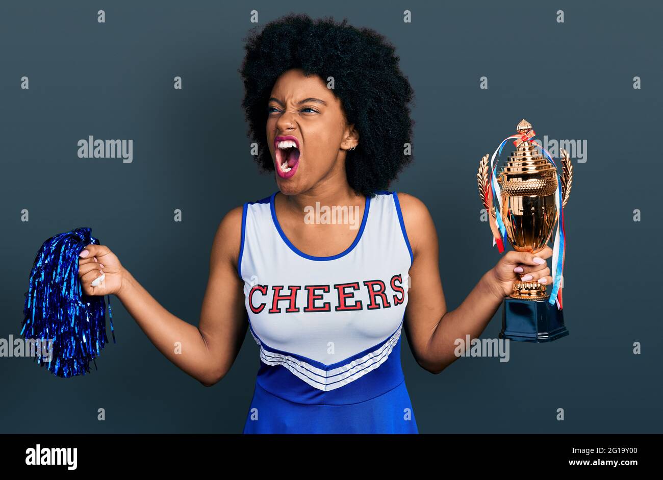Young african american woman wearing cheerleader uniform holding pompom ...