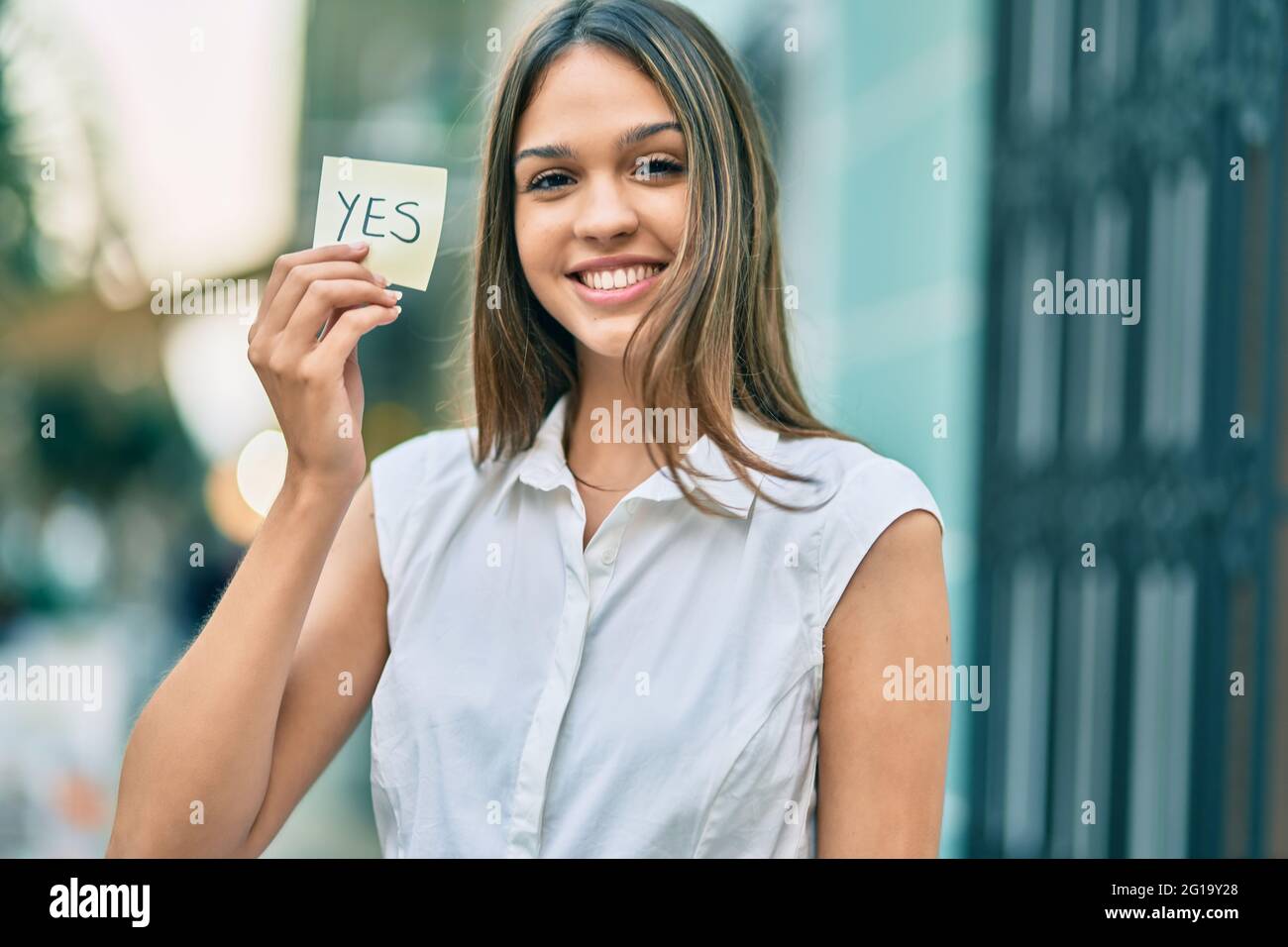 Beautiful latin teenager girl smiling happy holding yes reminder paper ...