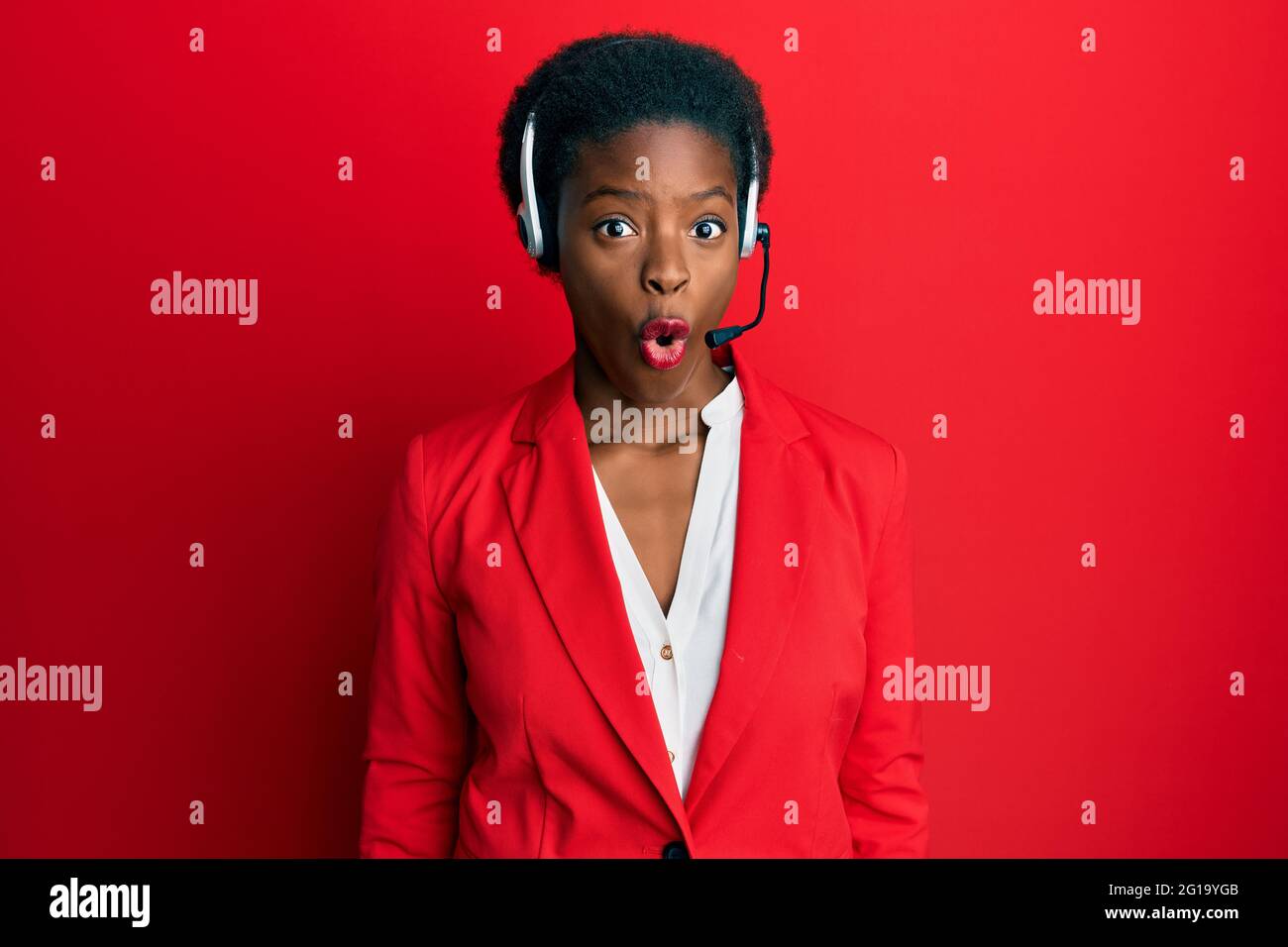 Young african american girl wearing call center agent headset scared ...