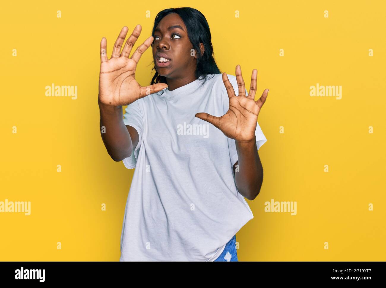 Young african american woman wearing casual white t shirt afraid and ...