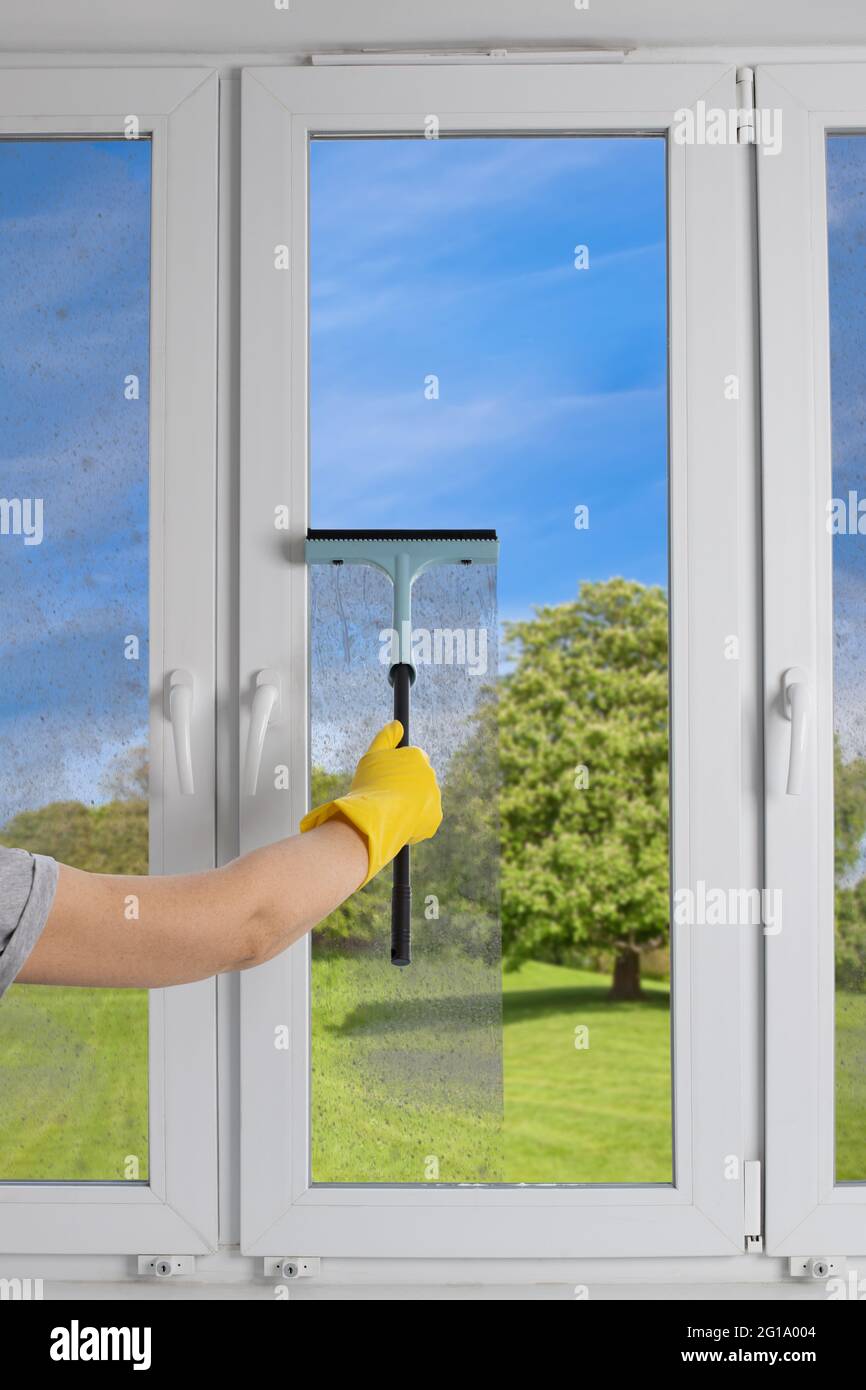 Cleaning modern PVC windows with a hand-held squeegee concept Stock ...