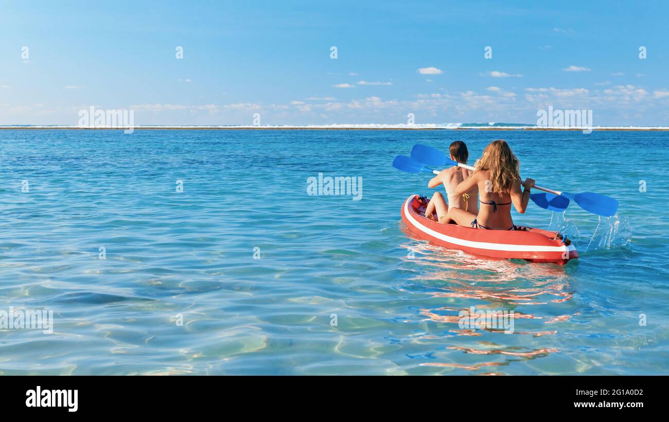 Young women have fun on boat walk. Girls paddling on kayak by sea ...