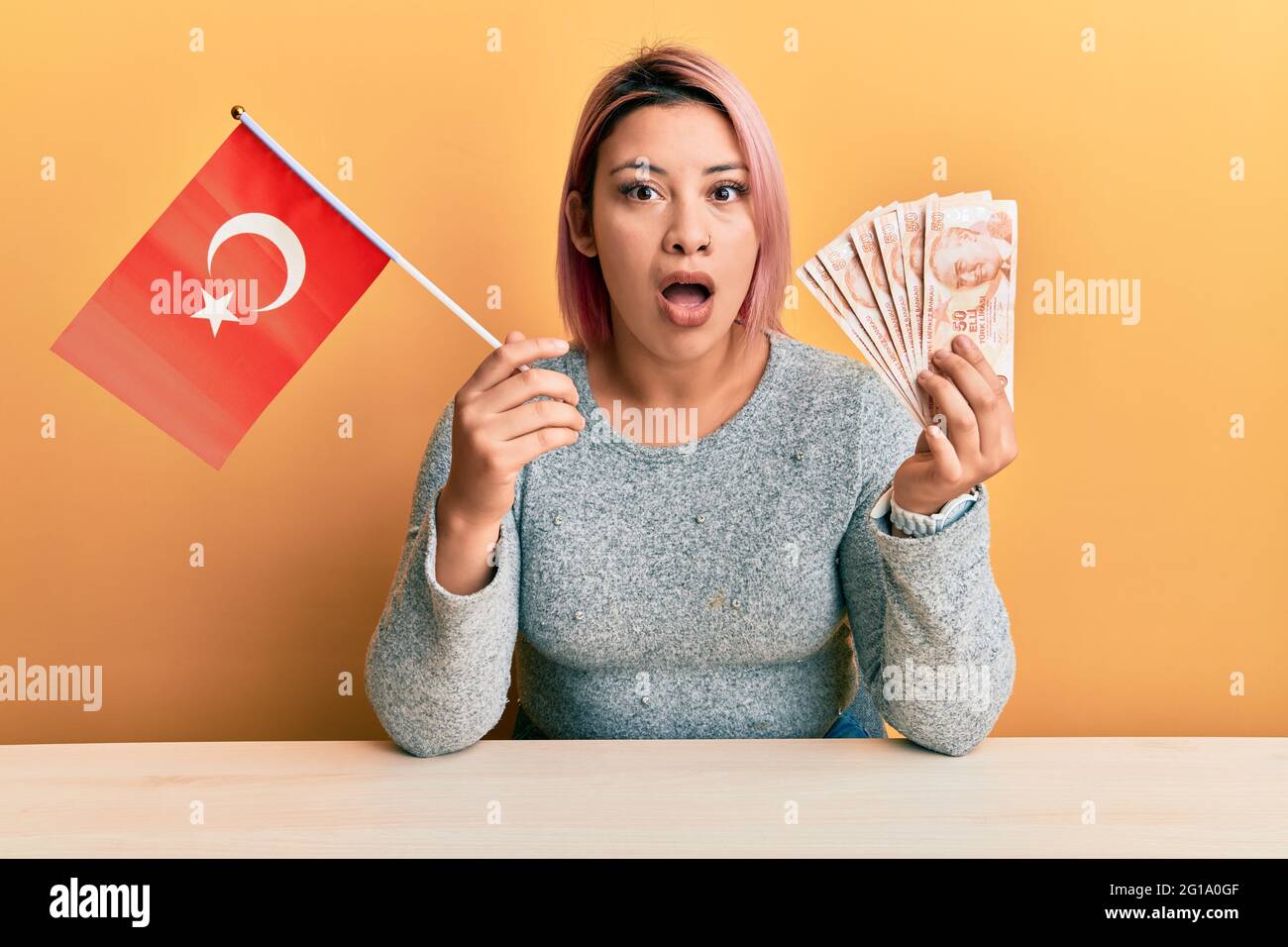 Hispanic woman with pink hair holding turkey flag and liras banknotes ...