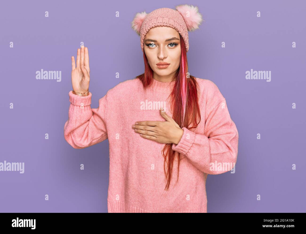Young caucasian woman wearing casual clothes and wool cap swearing with ...