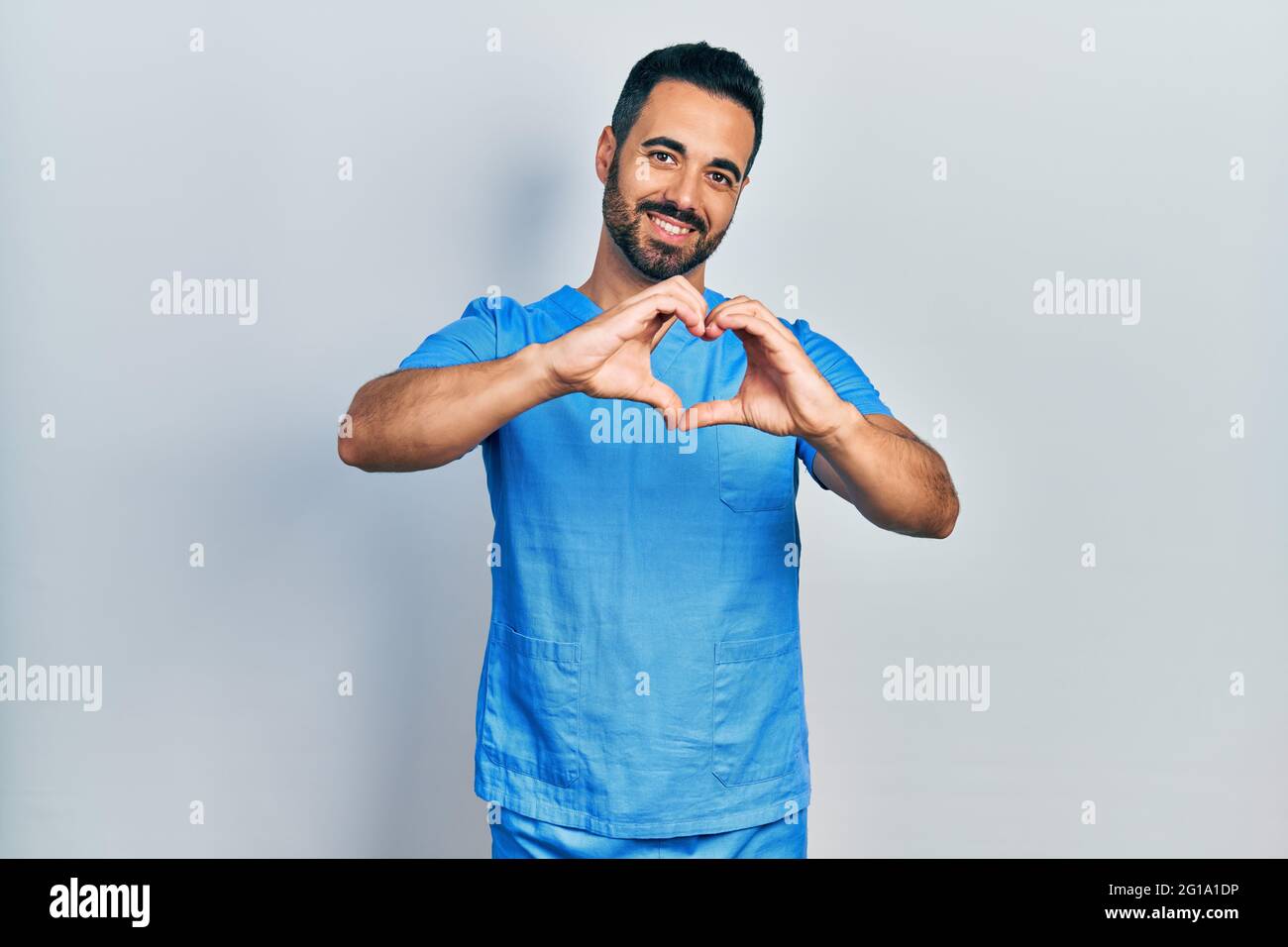 Handsome hispanic man with beard wearing blue male nurse uniform ...