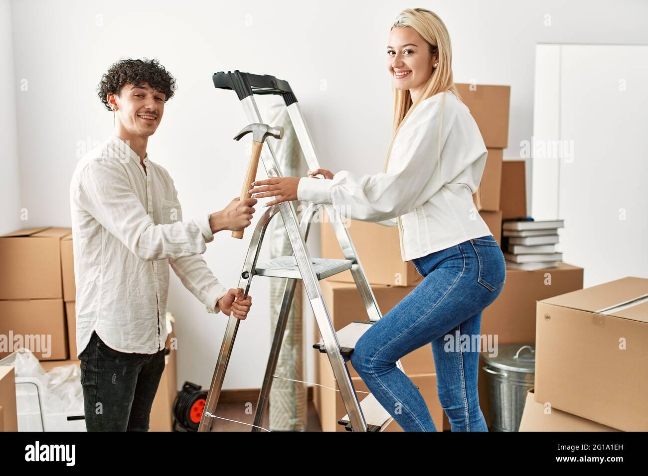 Young woman going up ladder at new home Stock Photo - Alamy