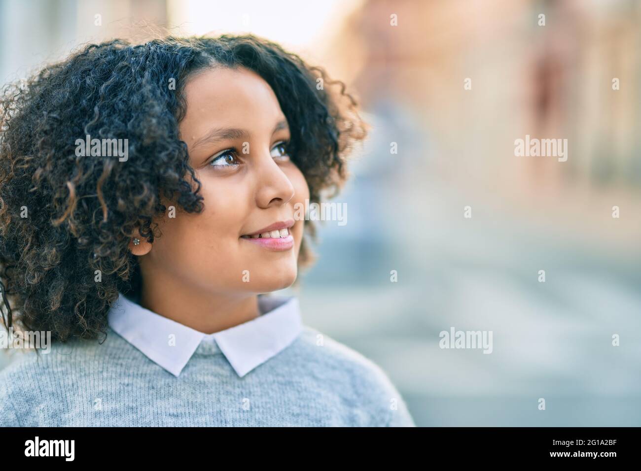 Adorable hispanic child girl smiling happy standing at the city Stock ...