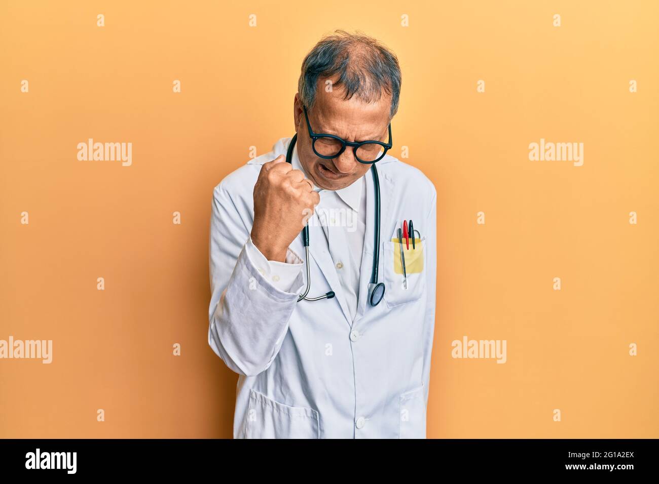 Middle age indian man wearing doctor coat and stethoscope angry and mad ...
