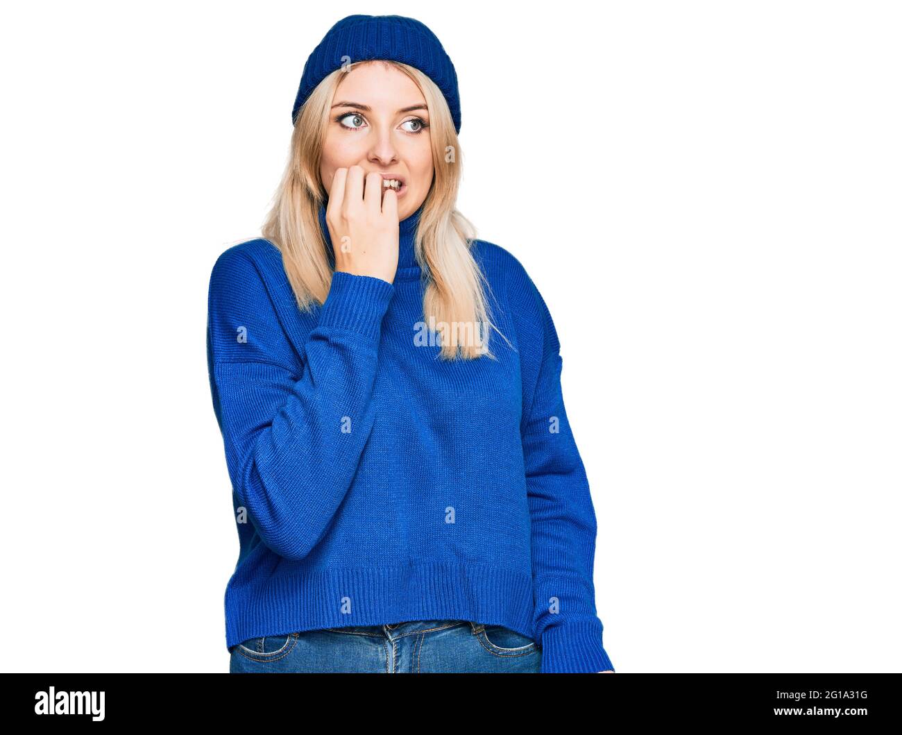 Young caucasian woman wearing wool winter sweater and cap looking ...