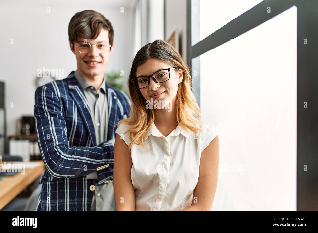 Two business workers smiling happy with arms crossed gesture at the ...