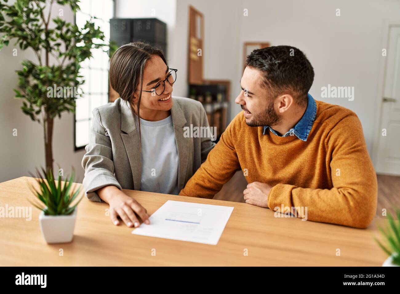 Couple smiling happy reading document at the office Stock Photo - Alamy