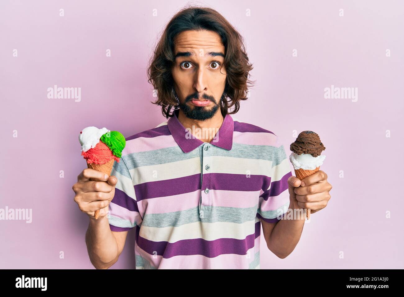 Young hispanic man holding ice cream depressed and worry for distress ...