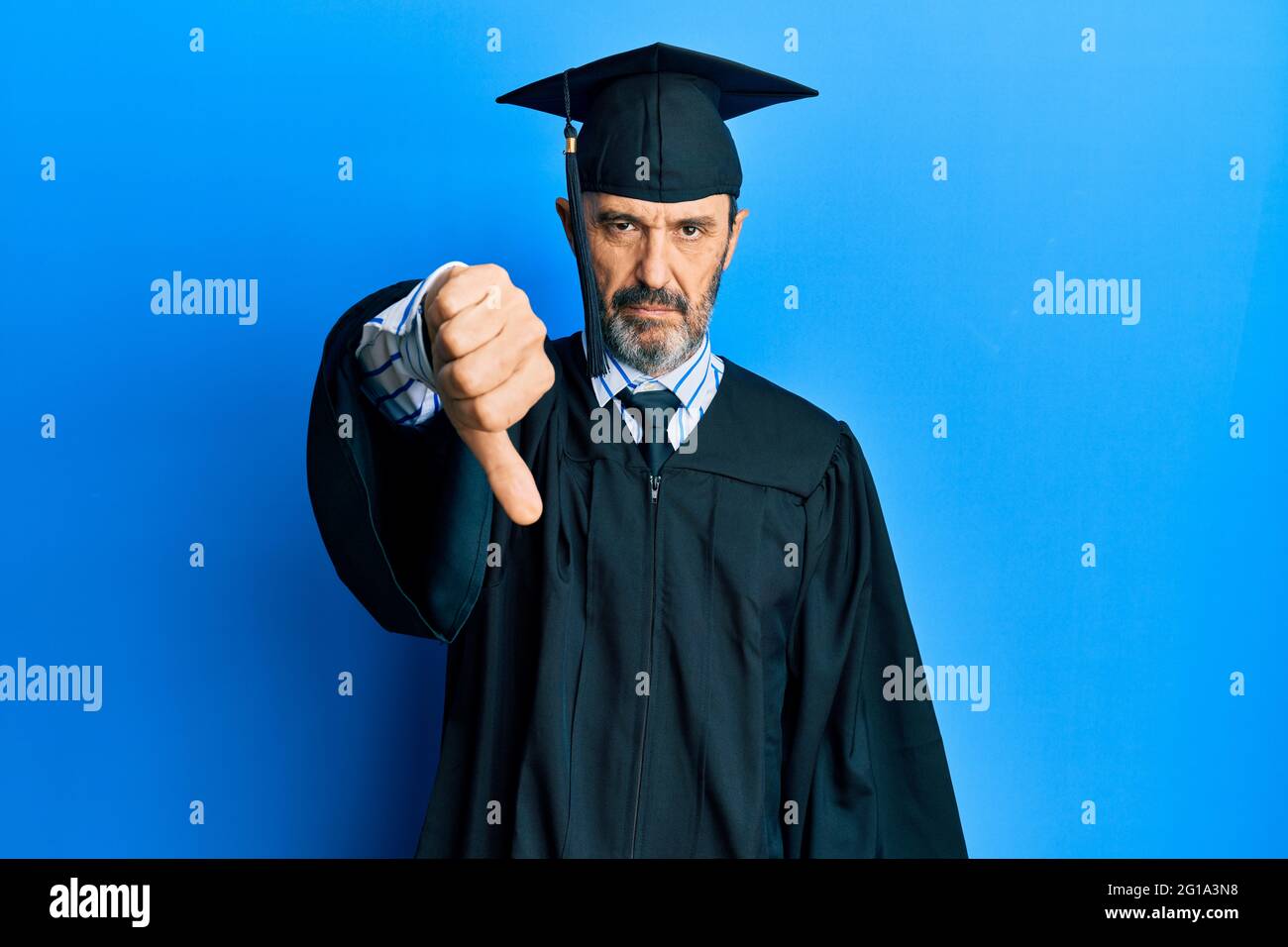 Middle age hispanic man wearing graduation cap and ceremony robe ...