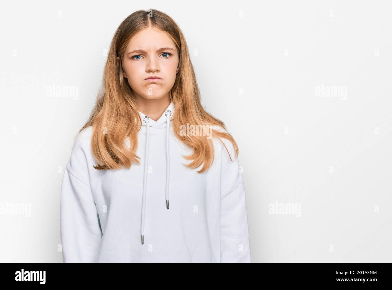 Beautiful young caucasian girl wearing casual sweatshirt puffing cheeks ...