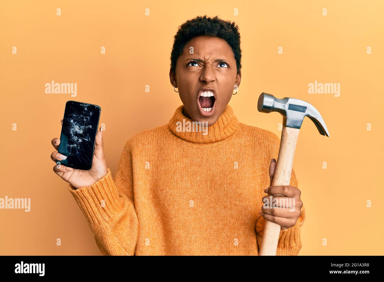Young african american girl holding broken smartphone showing cracked ...