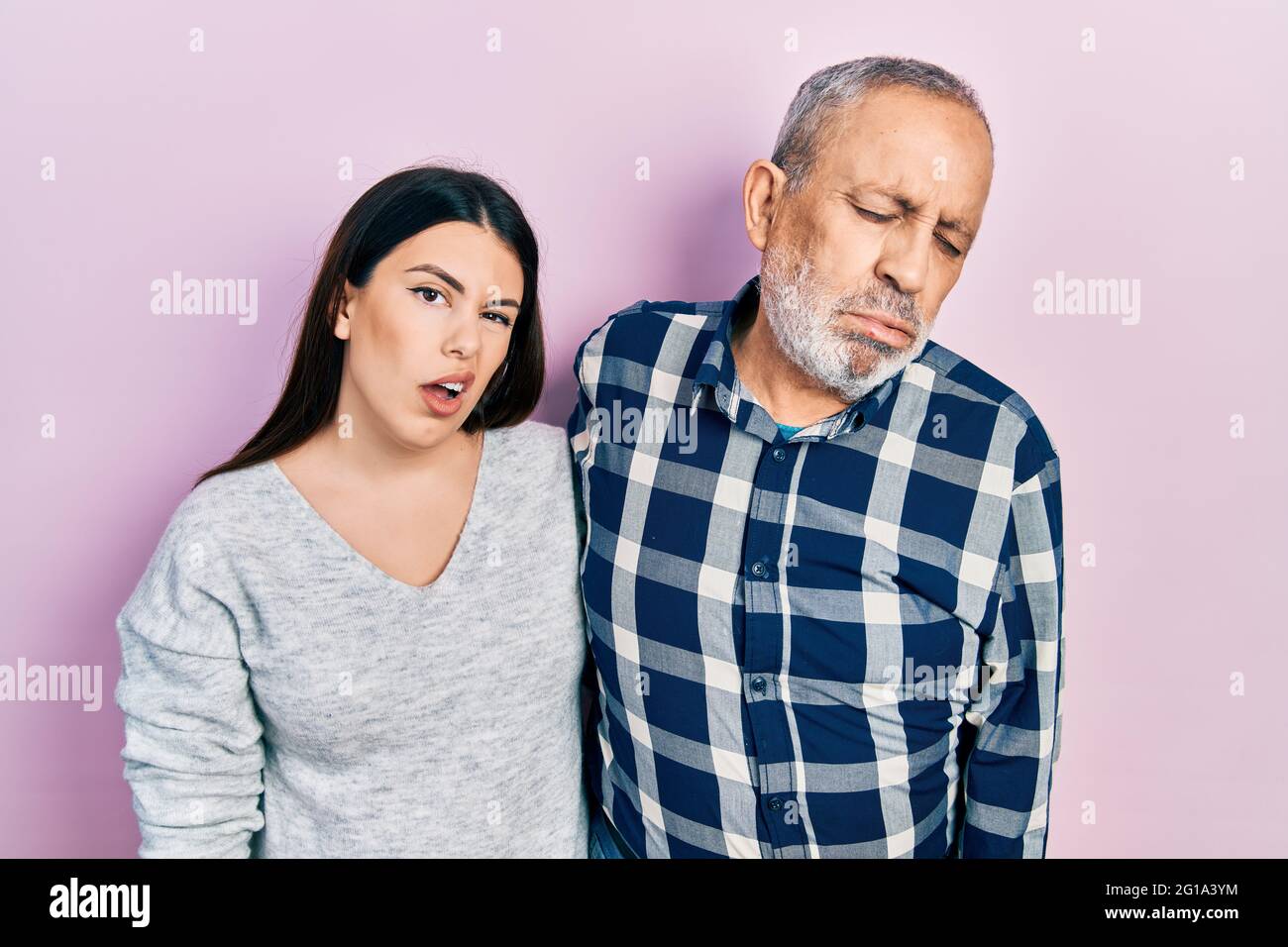 Hispanic father and daughter wearing casual clothes looking sleepy and ...