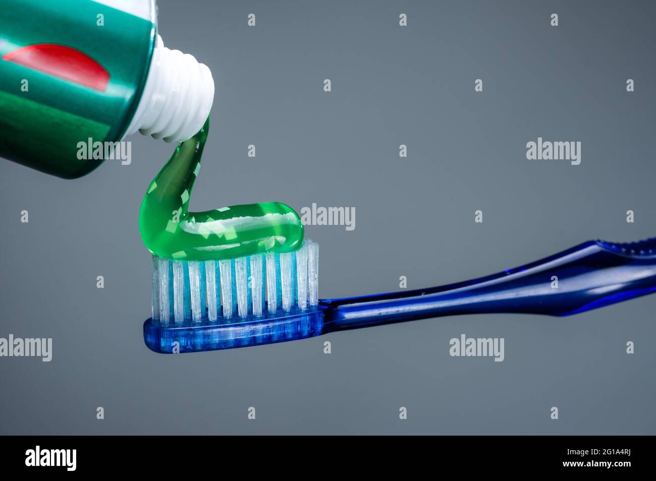 Squeeze toothpaste onto the brush. Green toothpaste on a toothbrush ...