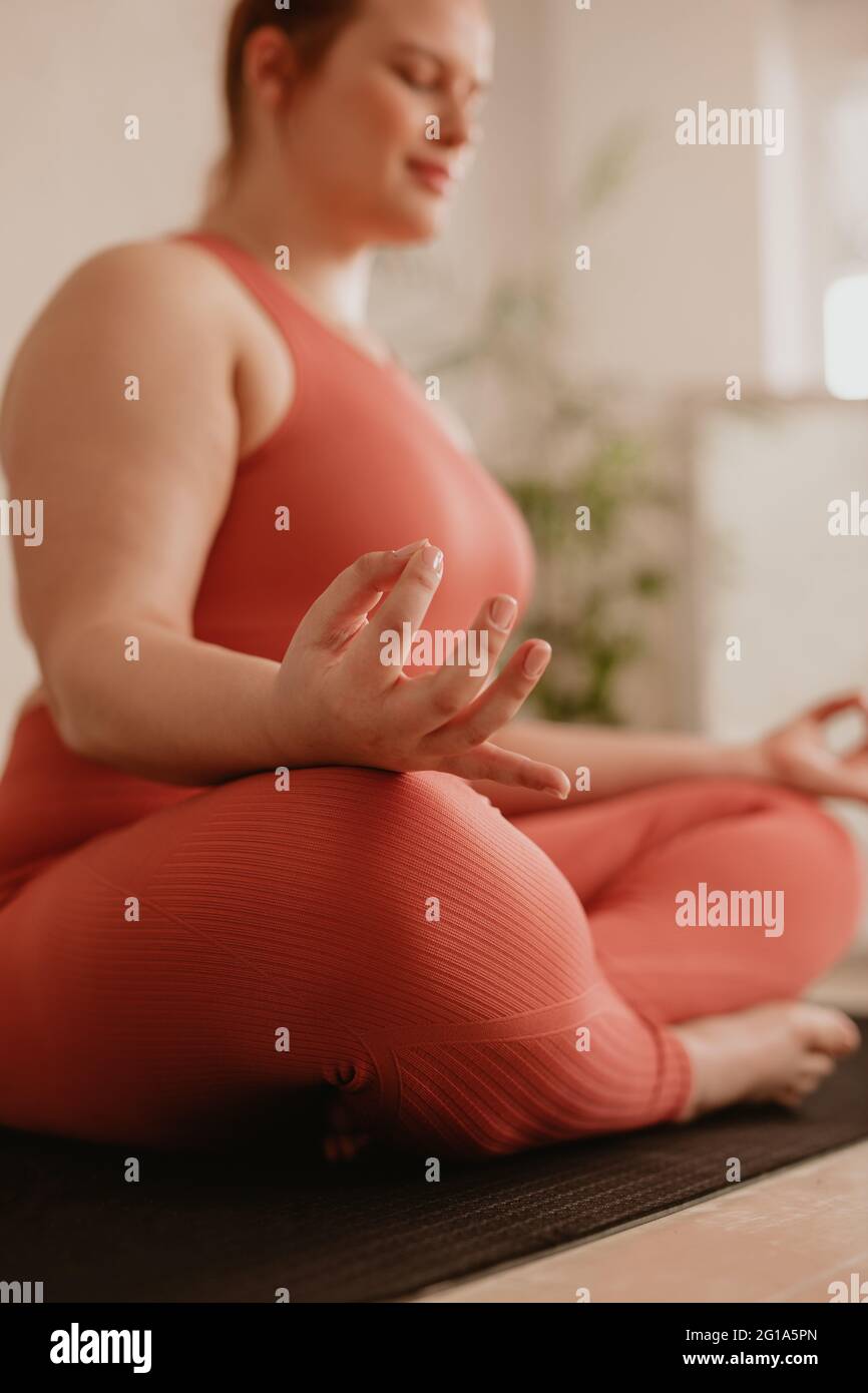 Woman sitting cross legged meditating hi-res stock photography and ...