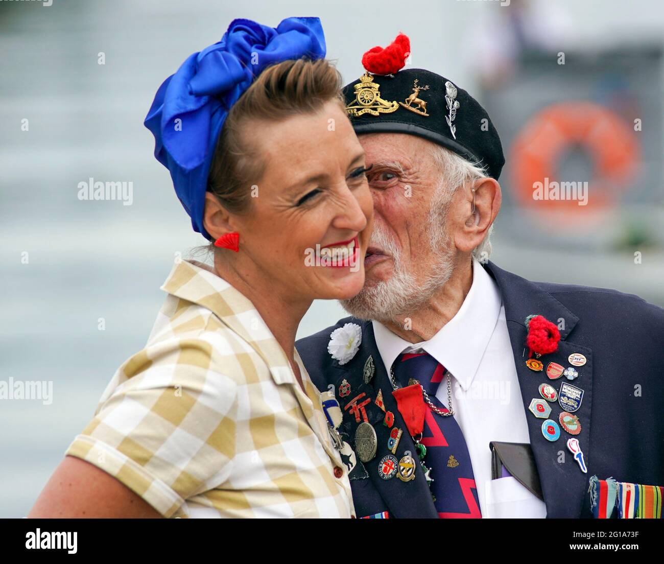 D-Day veteran Joe Cattini kisses a member of the Charlalas as he and ...
