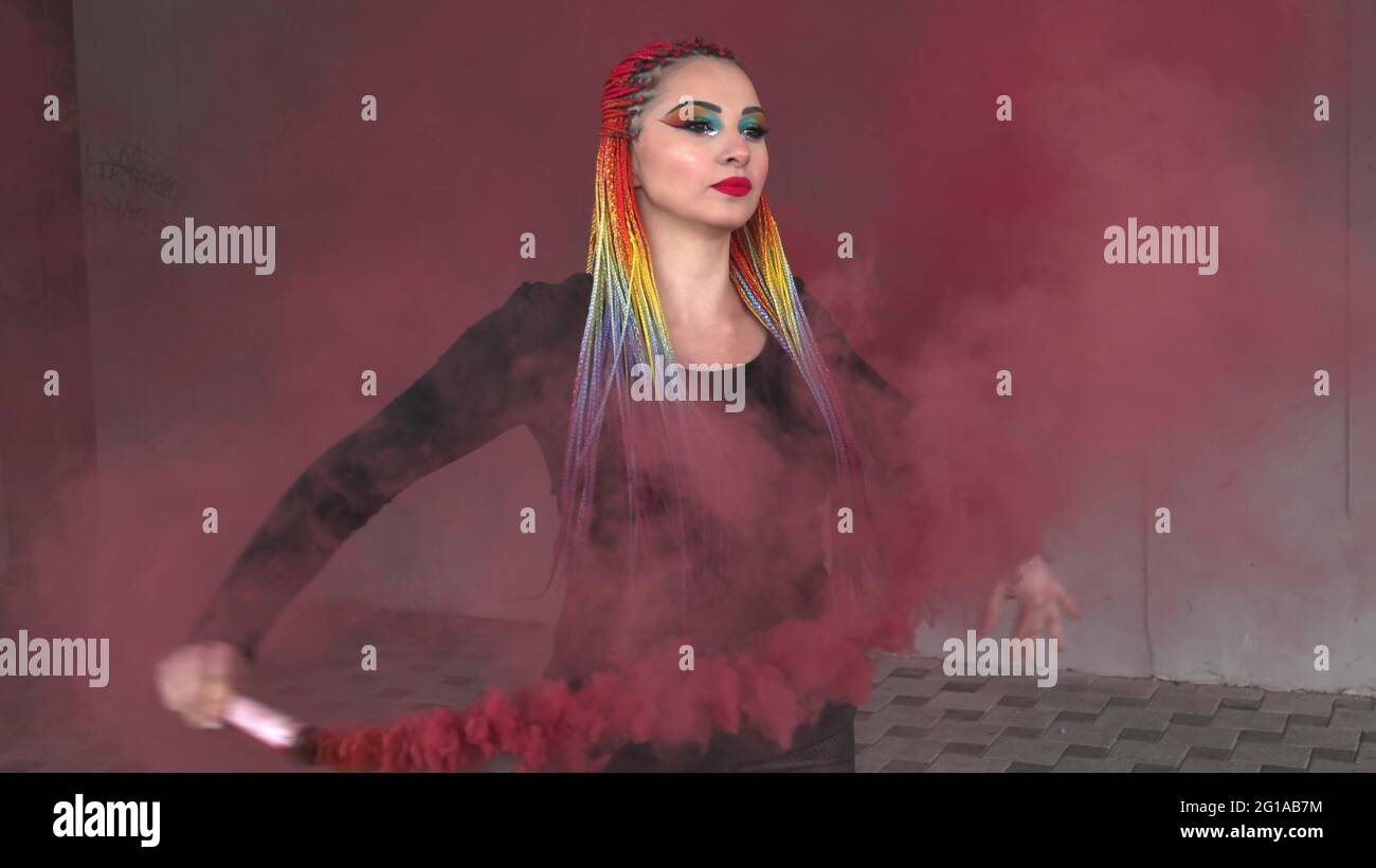 Attractive girl with multicolored braids and makeup in an black dress ...