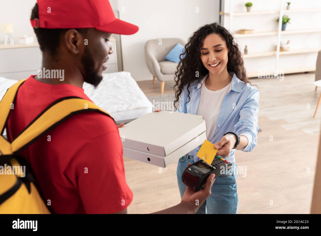 Black delivery man holding POS machine for payment Stock Photo - Alamy