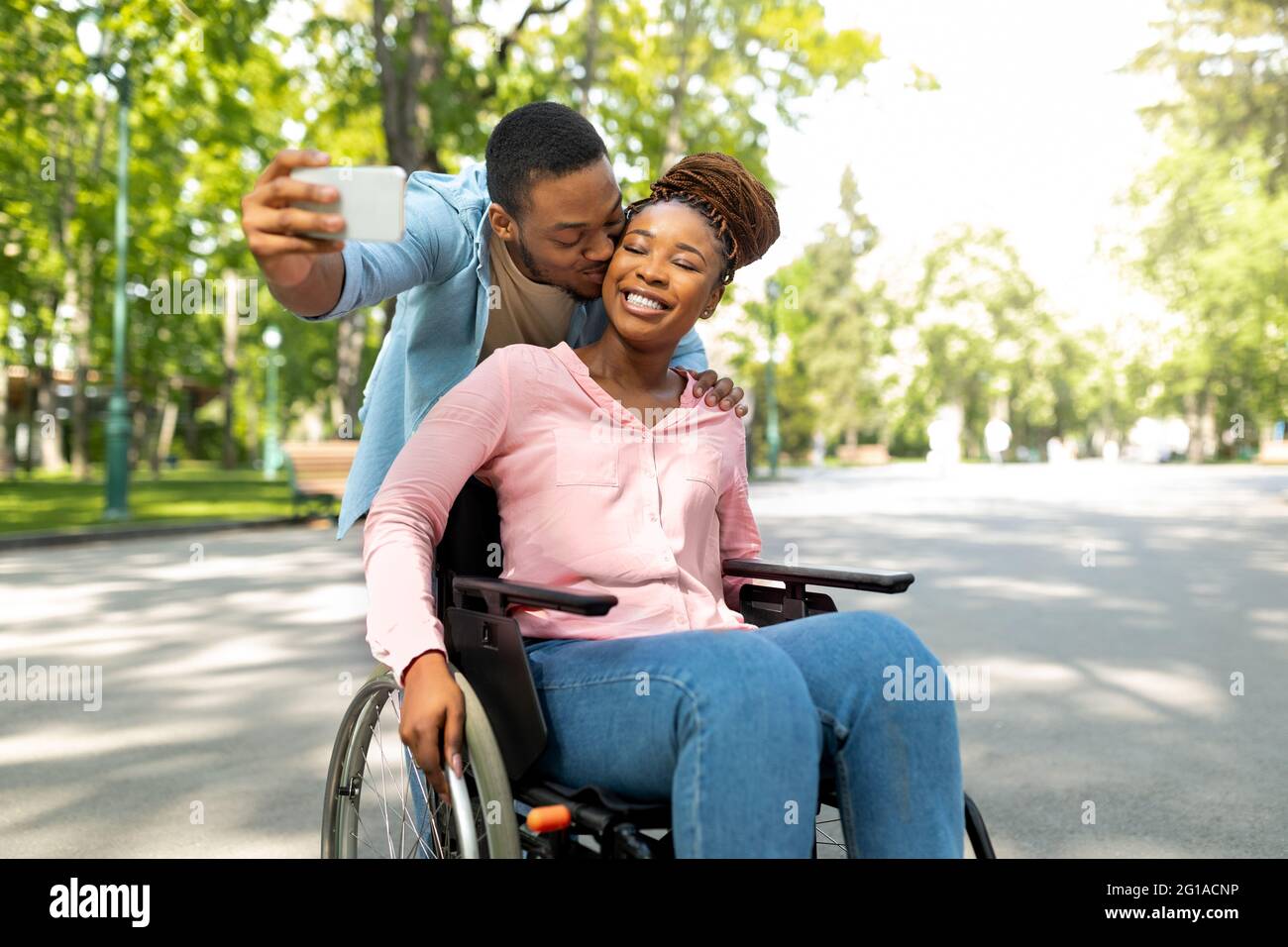 Romantic black man and his impaired girlfriend in wheelchair taking ...