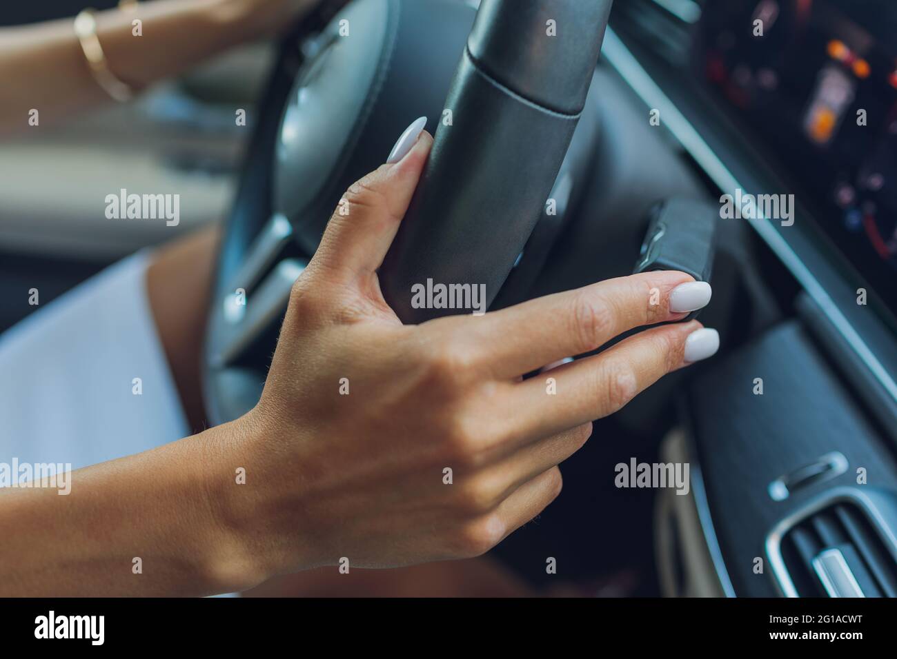 Woman's hand switches the lobes of the gear selector on the steering ...