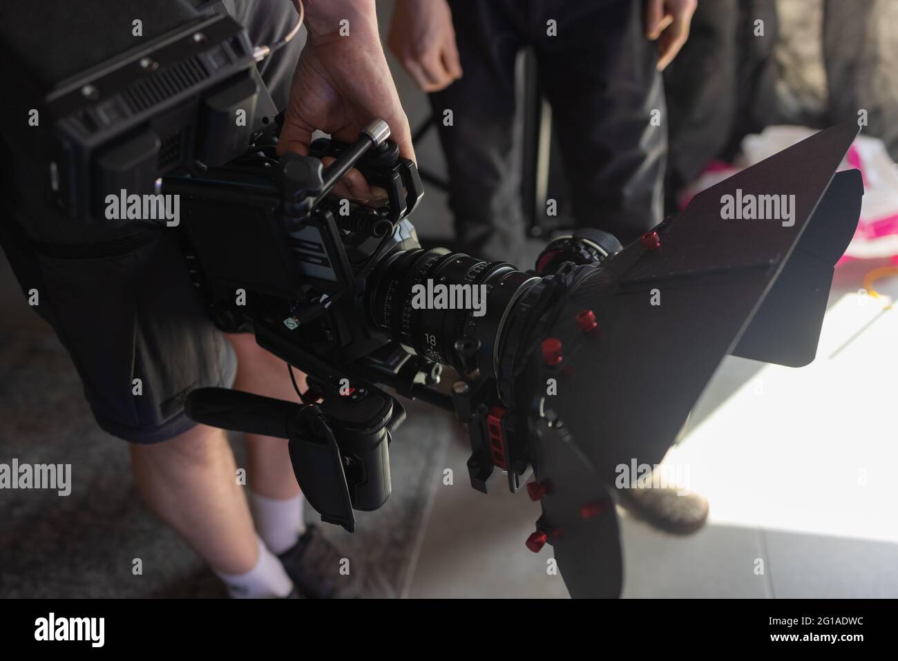 Filming process. Cameraman holding camera in his right hand outside ...