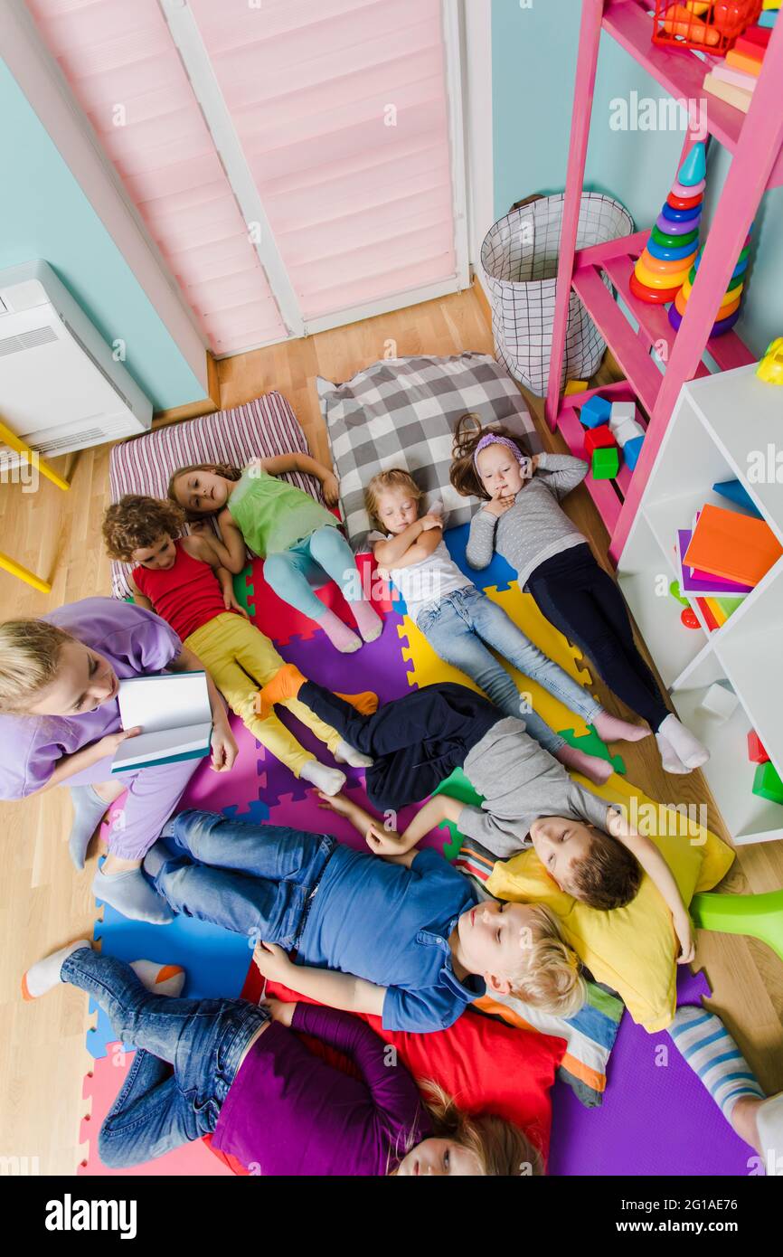Active kids laying on soft pillows and mats at the kindergarten Stock ...