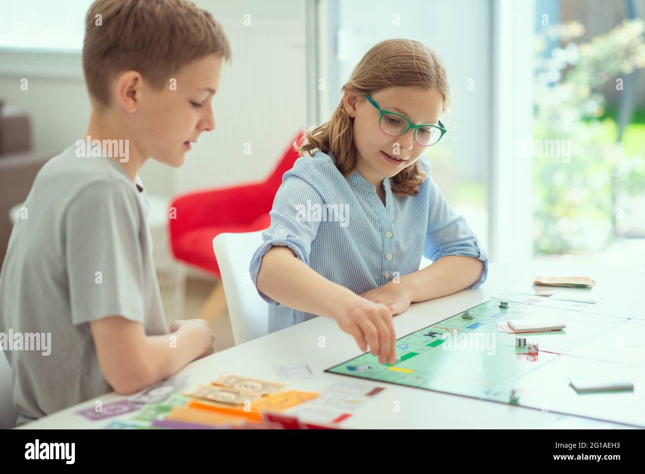 Happy cute children playing board games and having fun together at home ...