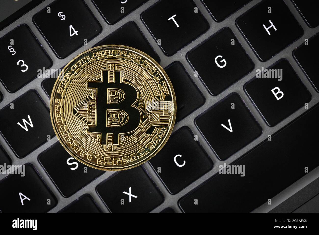 Bitcoin physical coin laying on a laptop keyboard Stock Photo - Alamy