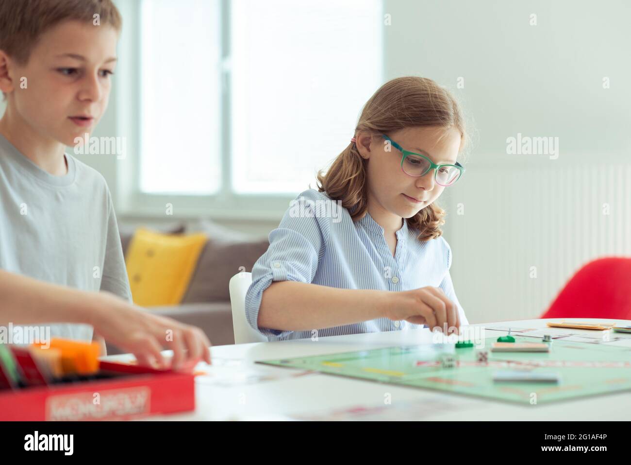 Happy cute children playing board games and having fun together at home ...