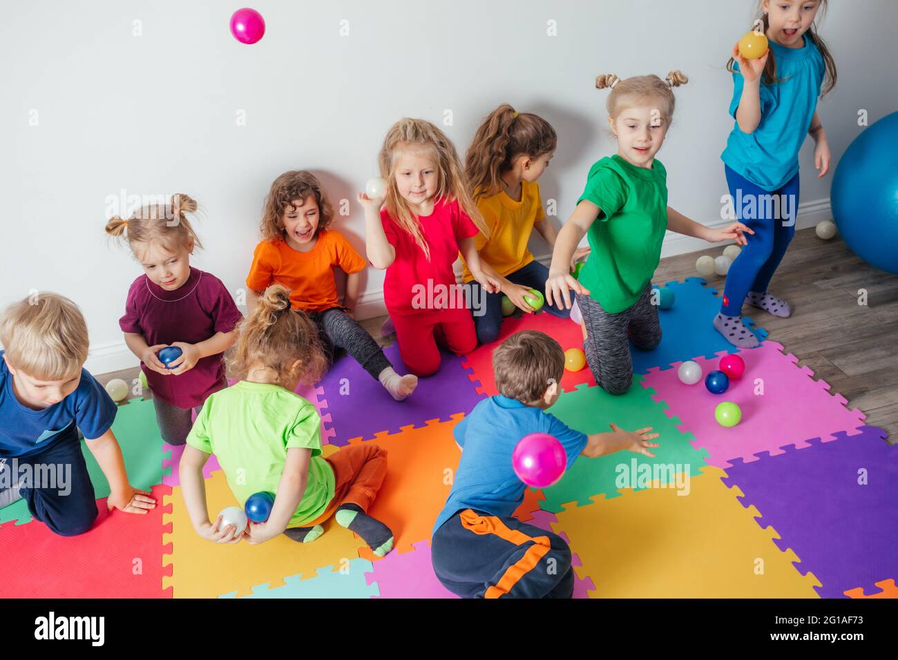 Energetic youngsters throwing away many colorful balls Stock Photo - Alamy