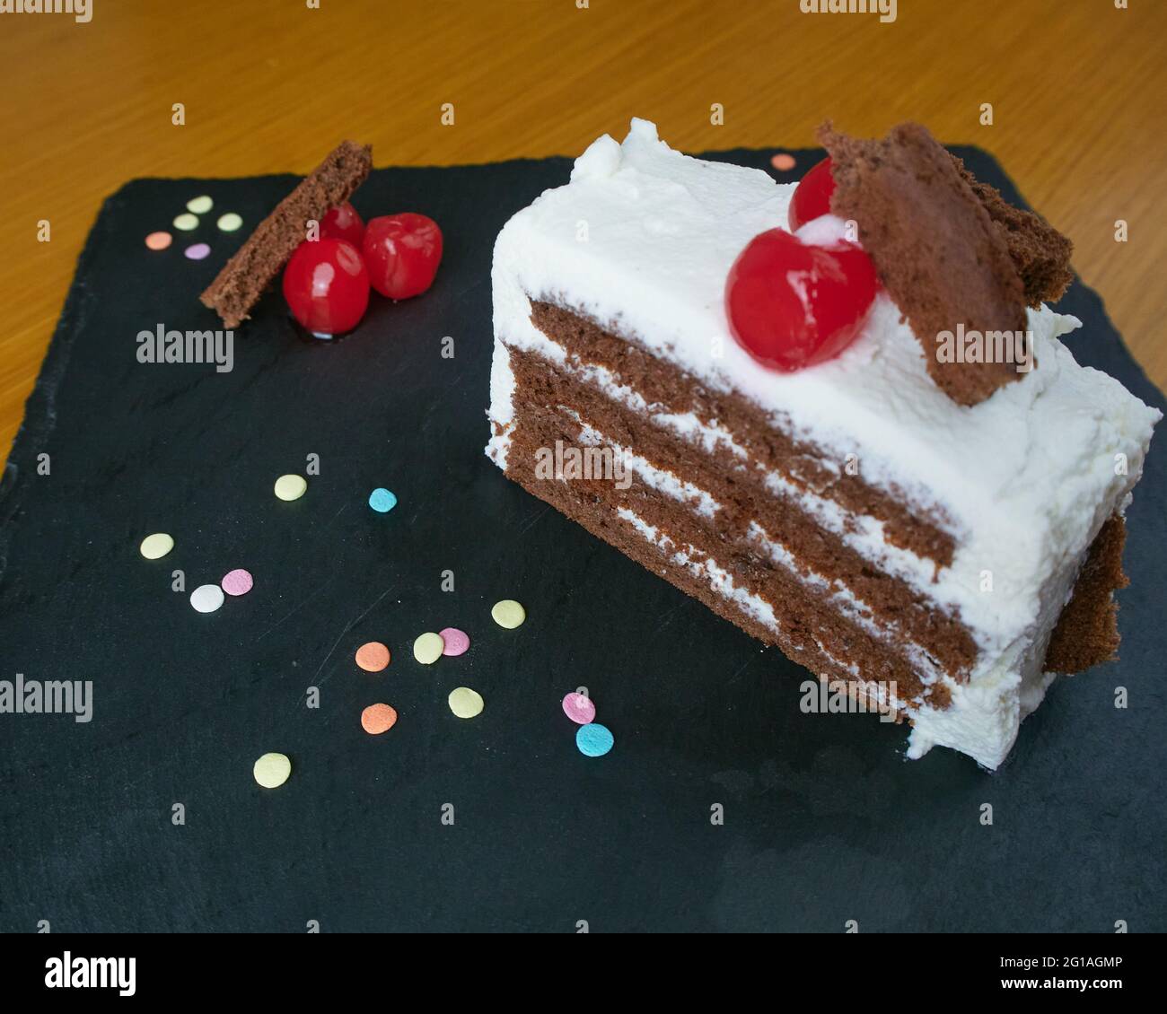 Black forest slice decorated with cherries, small pieces of cake and ...