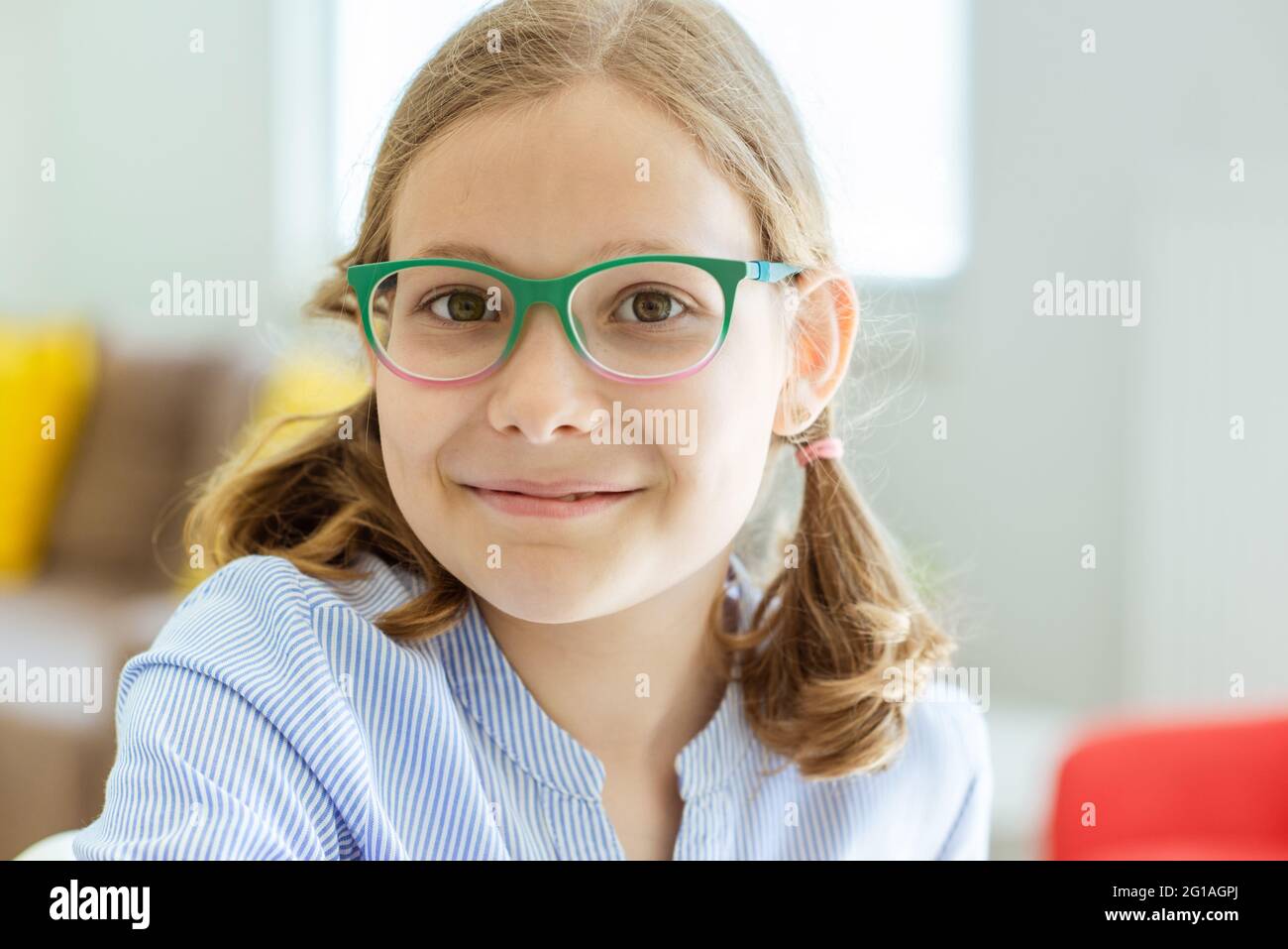 Portrait of cute little teen girl in glasses with funny pigtails ...