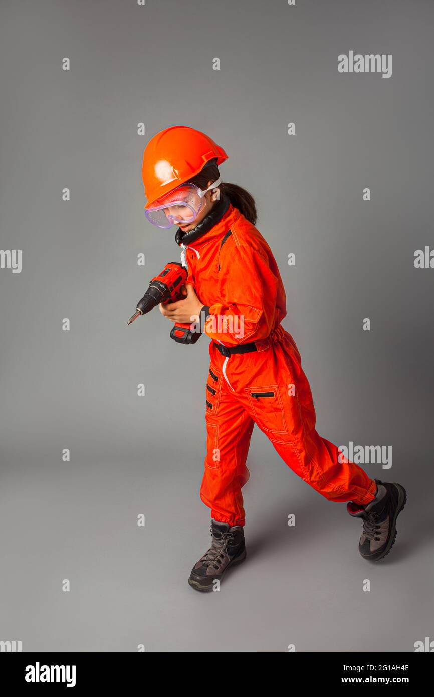 The little girl dressed in a red engineering uniform is holding a ...