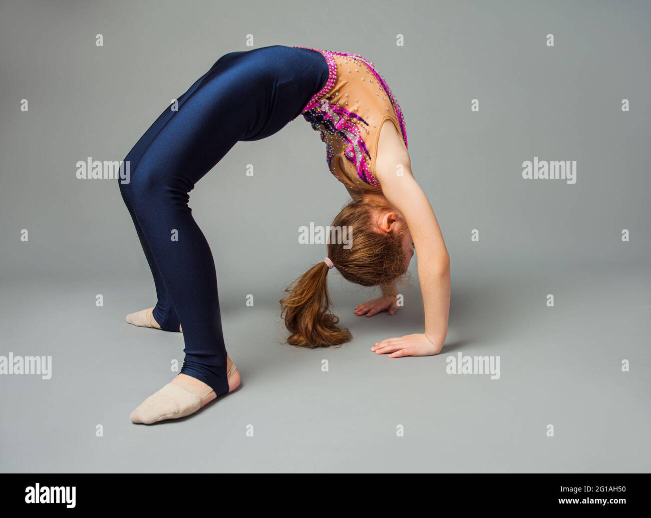 The little girl is stretching in a bright sports costume Stock Photo ...