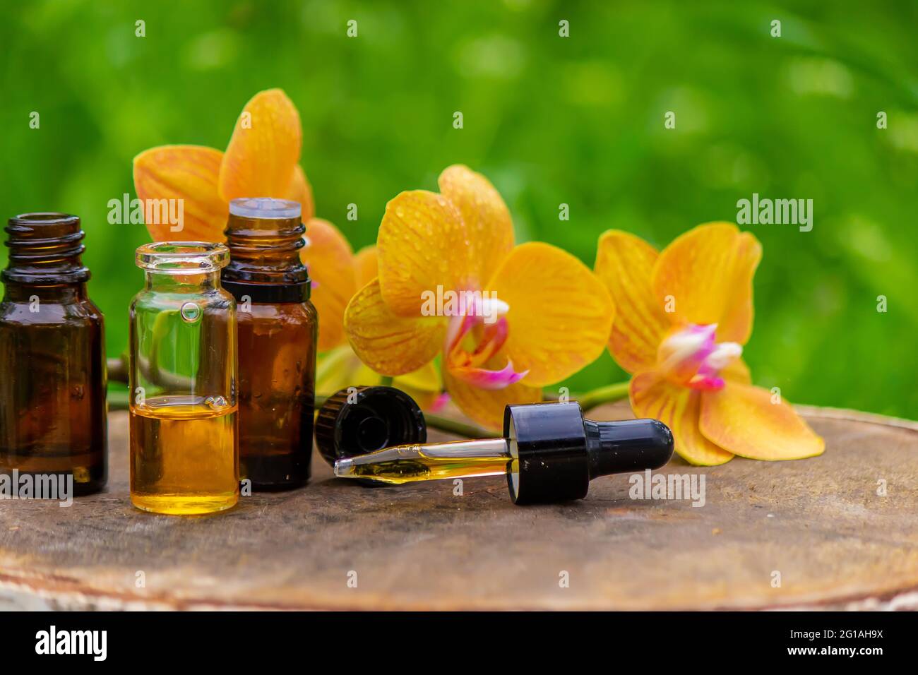 Massage oil and stones with yellow orchid. Natural oils. Selective ...