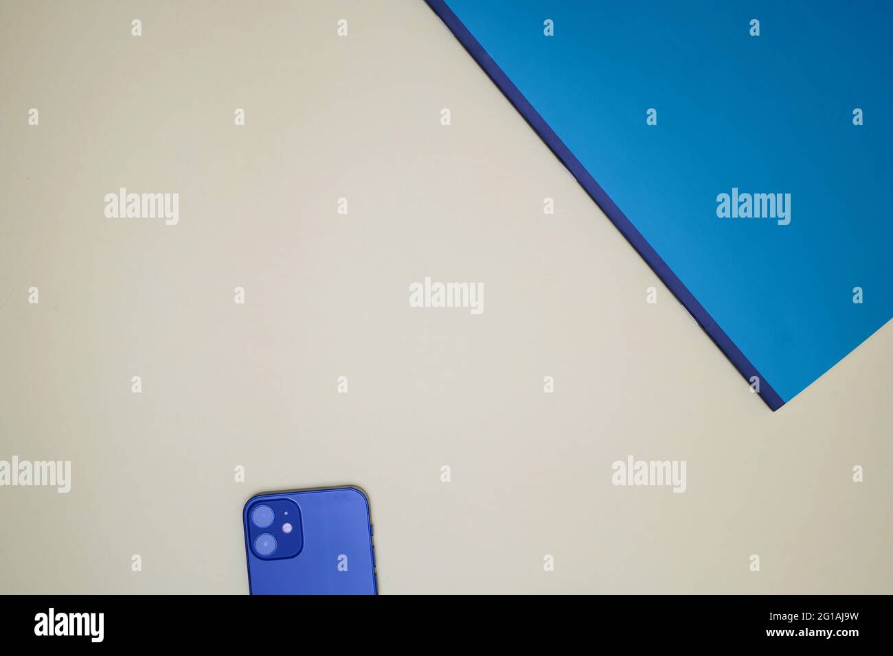 Office flat lay with pen and notebook placed on a light orange ...