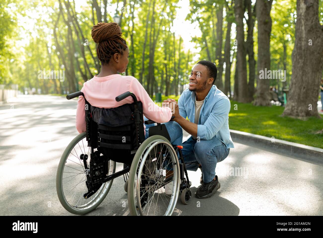 Tender black guy holding his disabled girlfriend's hand, expressing ...