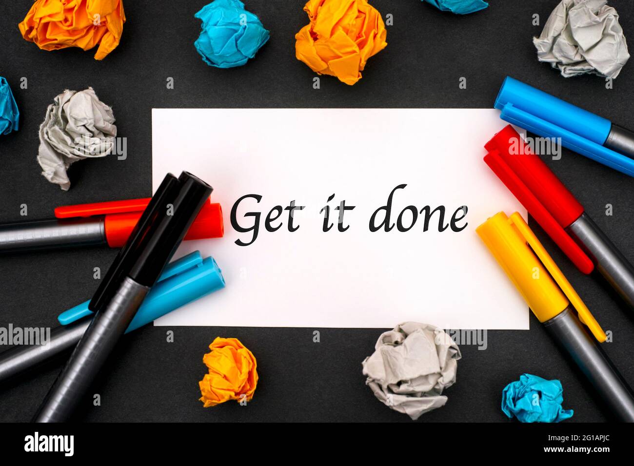 Words Get It Done on white paper blank with colour pens and crumpled ...
