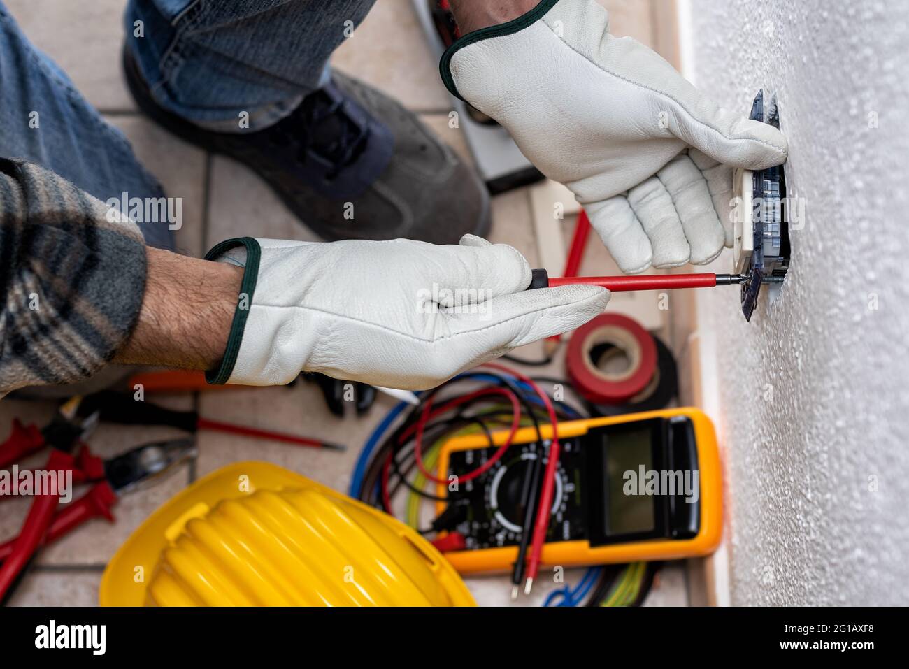 Top view. Electrician worker at work installs the electric socket of a ...