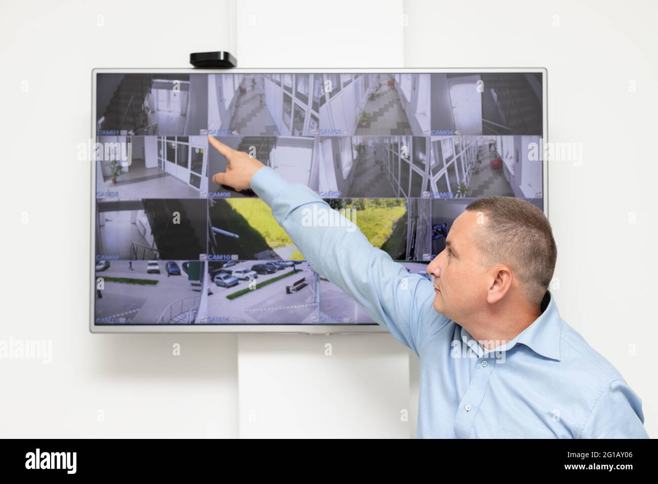 security guard standing in front of large CCTV monitor Stock Photo - Alamy