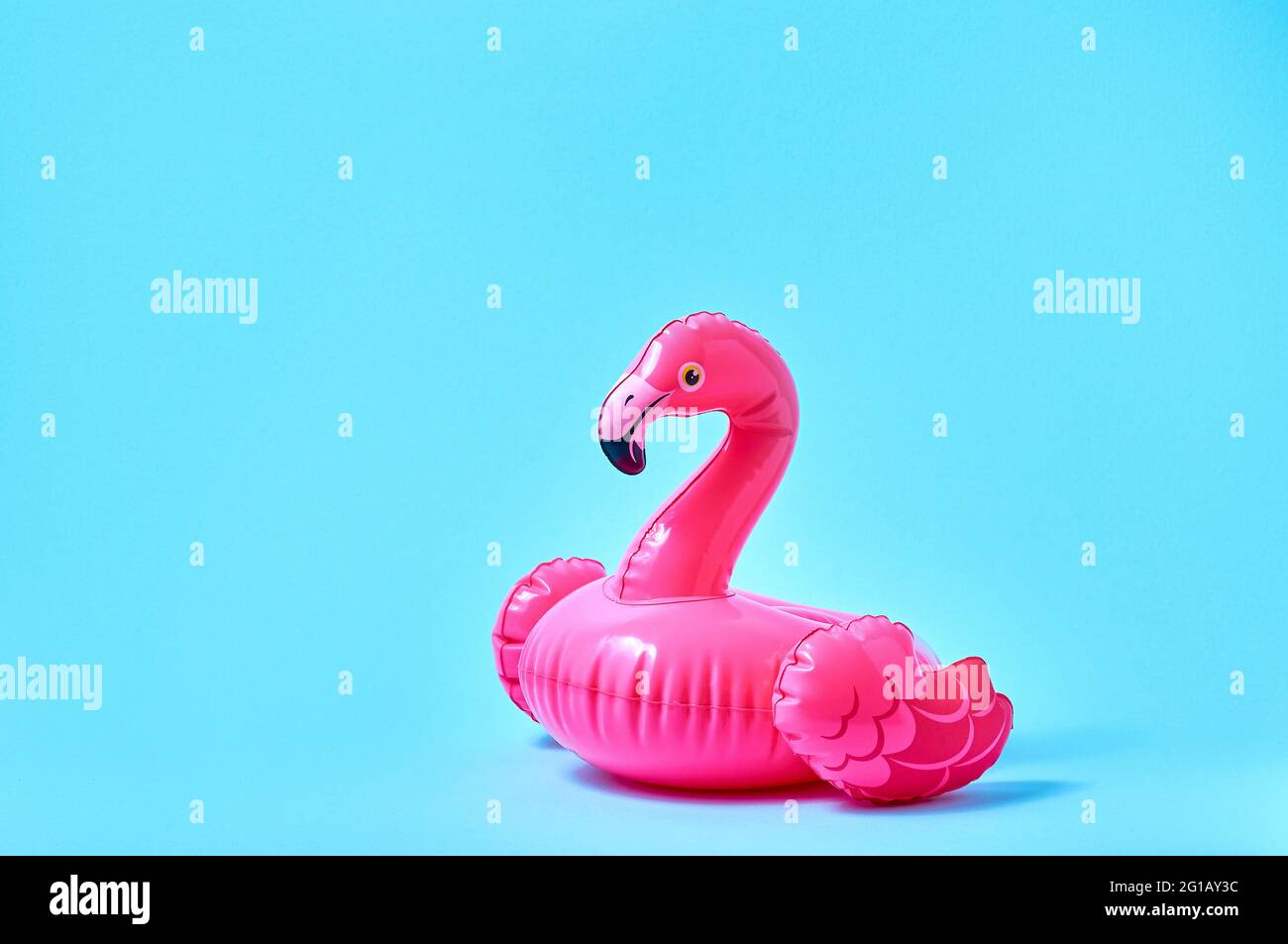 Inflatable pink flamingo pool toy on blue background. Creative minimal ...