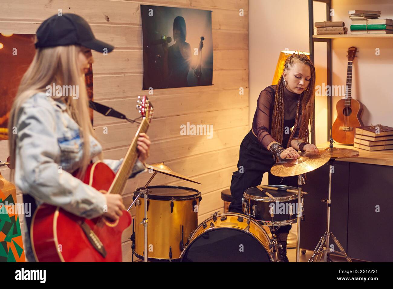Girls with musical instruments preparing for music recording in studio ...