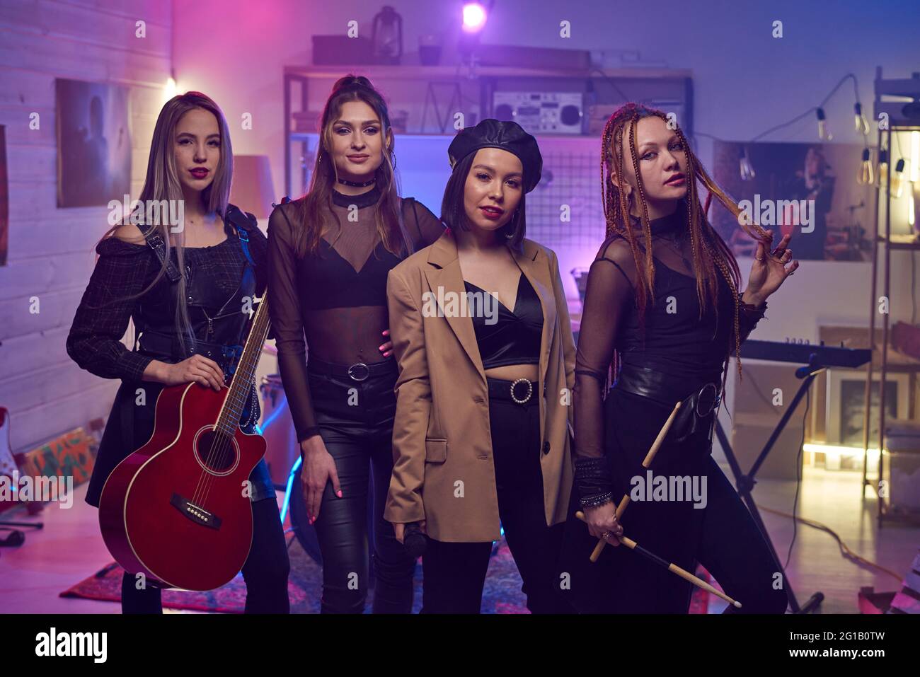 Portrait of young rock band of females with microphone and boom box ...