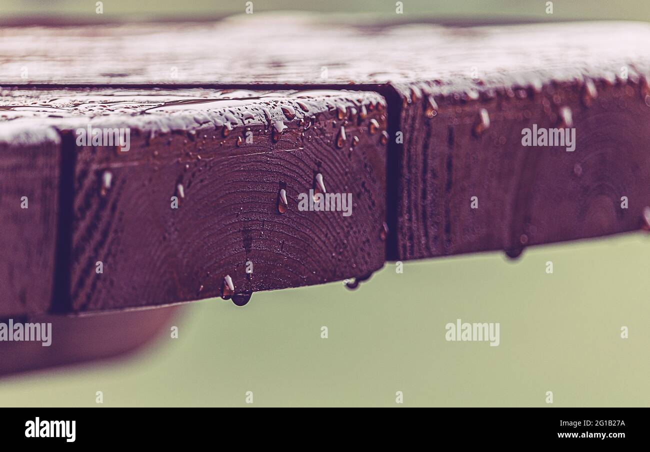 Drops on a wooden garden table in a warm summer rain - Rainy summer day ...