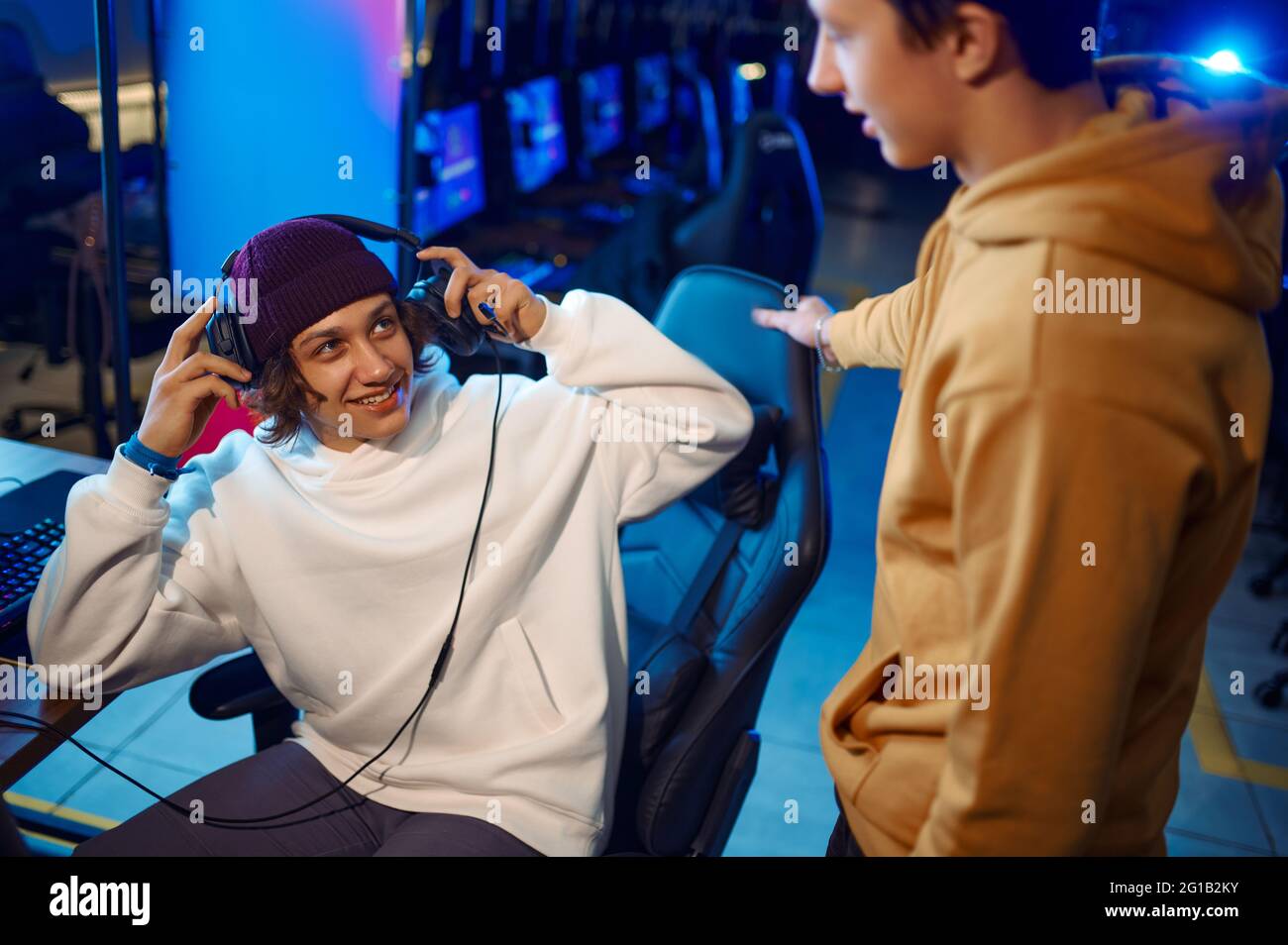 Two gamers talking at the monitor in gaming club Stock Photo - Alamy